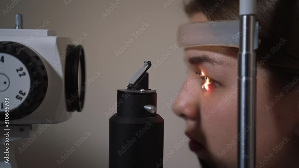 Video Stock Young pretty girl is checking eyesight with special optic ...
