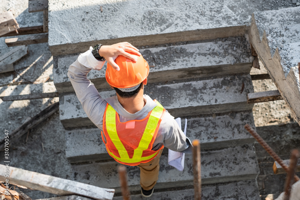 Male architect or engineer wearing hard hat at new building ...