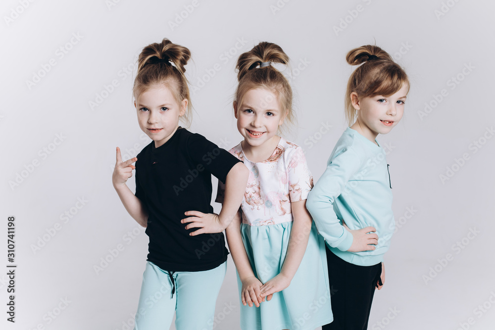 Happy cute adorable triplets girls posing in studio together on ...
