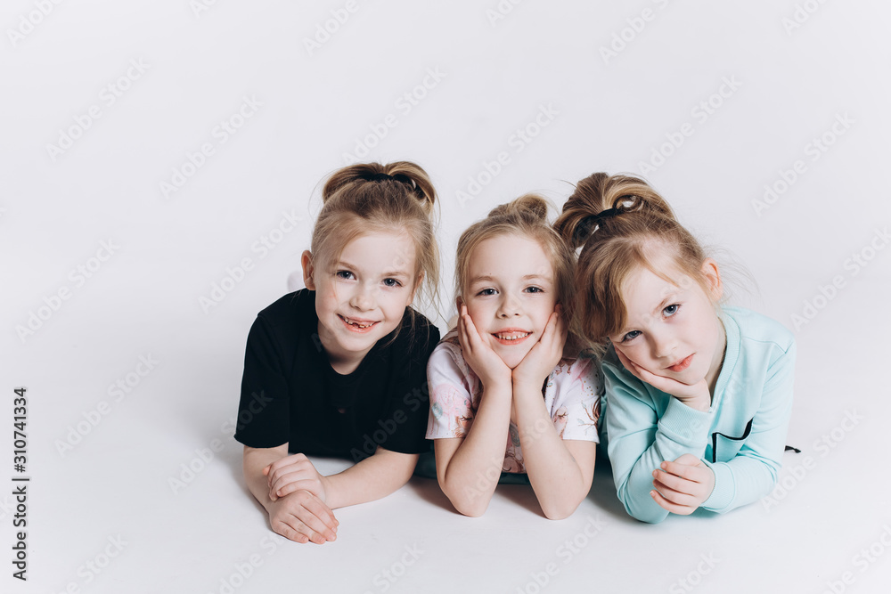 Happy cute adorable triplets girls posing in studio together on ...
