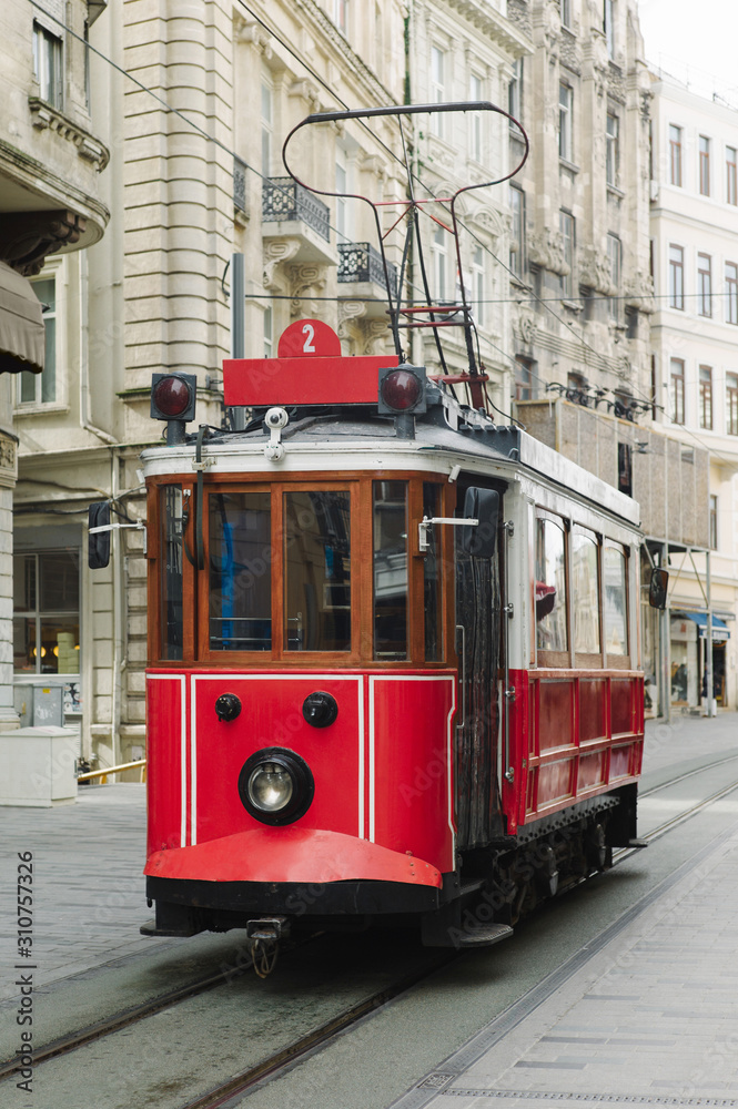 Retro tram driving on street between vintage buildings. Istiklal street ...