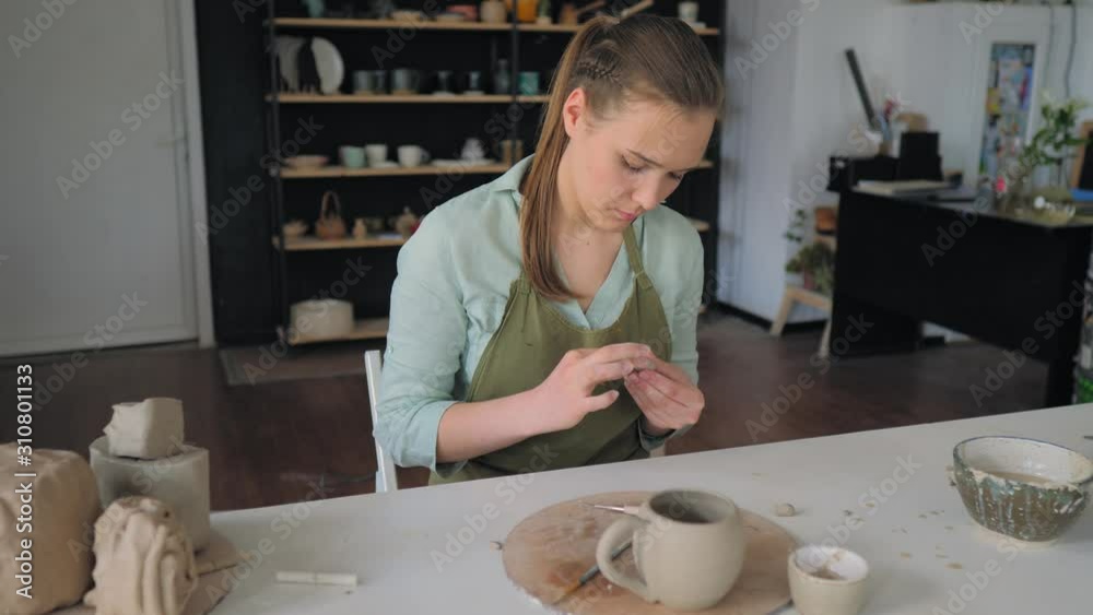 Vidéo Stock The girl attaches the handle to the clay cup. Creating cup ...