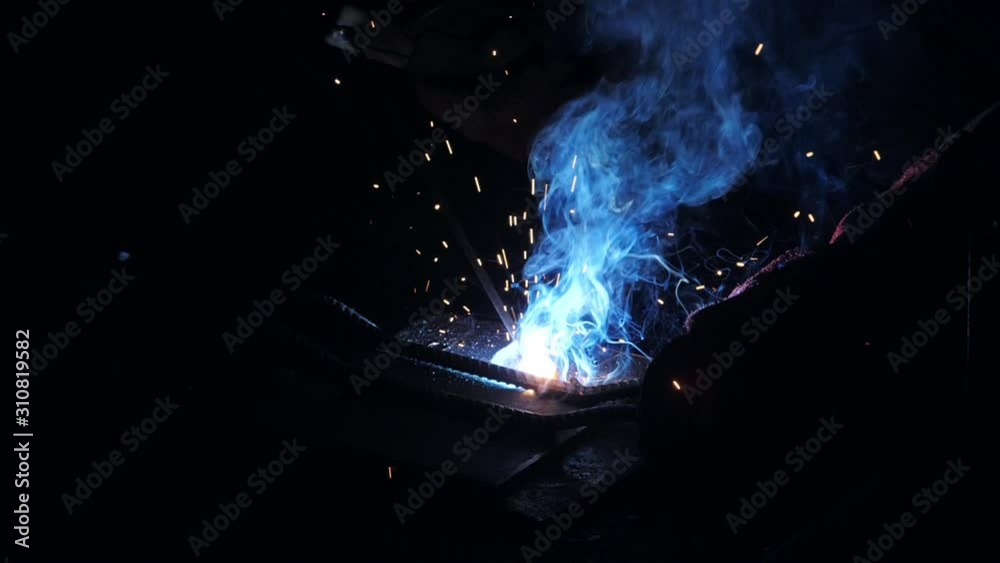 Welder working with welding machine. Bright flashes and smoke.. Welding ...