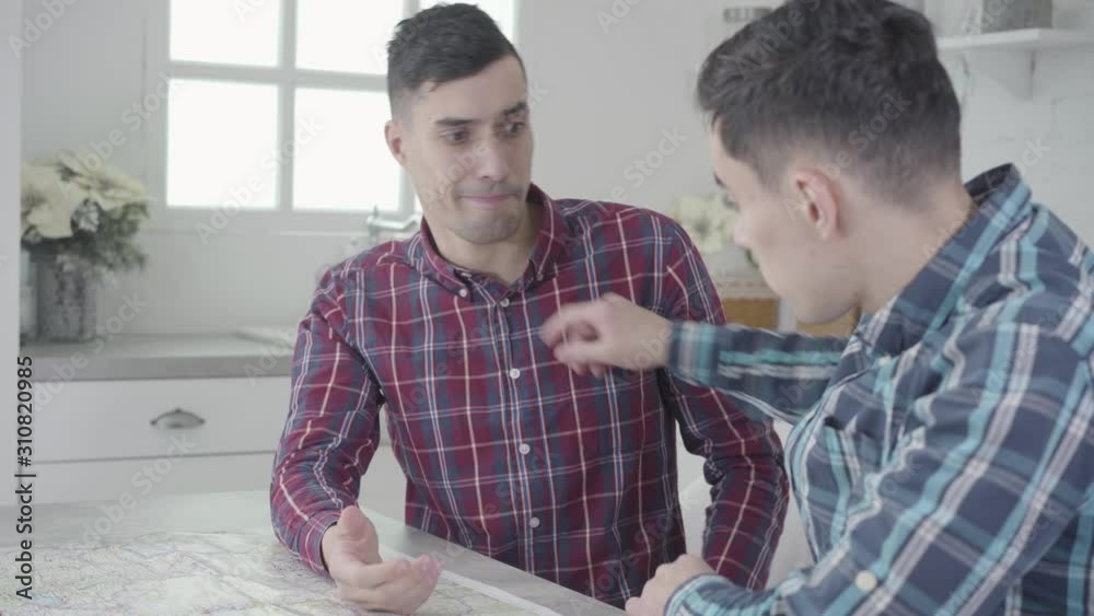 Portrait of identical twin brothers arguing about outfit. Brothers ...