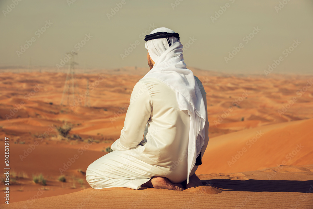 Arab Emirati man sitting on top of a dune in UAE desert Stock Photo ...