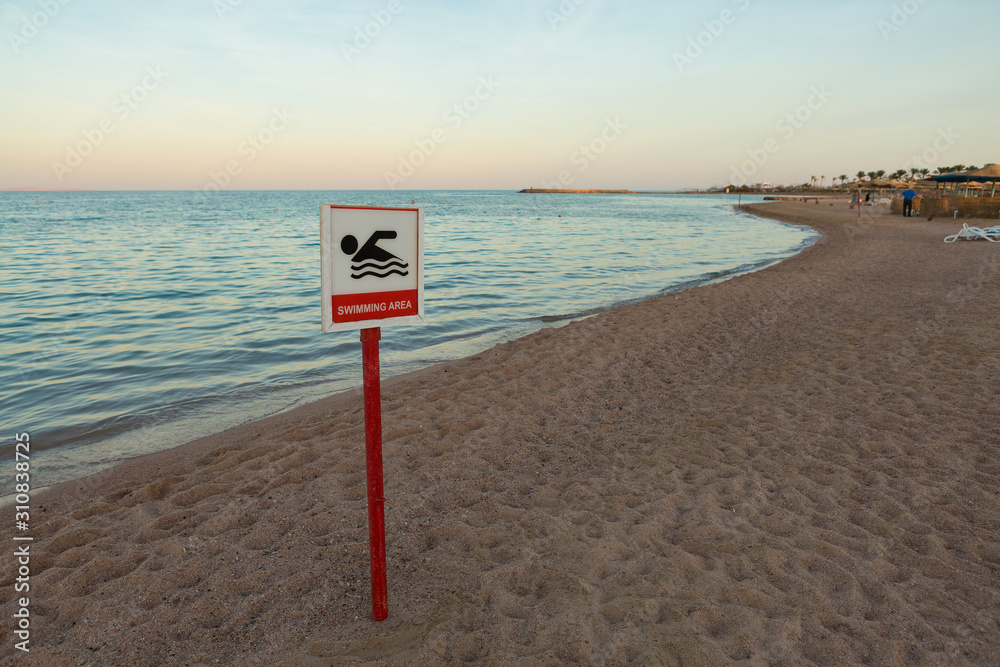 No swimming area sign on the sea beach. Crossed out floating person ...