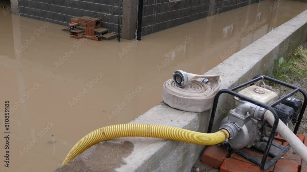 Footage of a flooded area and people pumping out water with a heavy ...