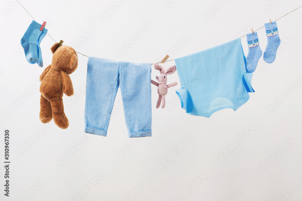 baby clothes hanging on rope on white background Stock Photo | Adobe Stock