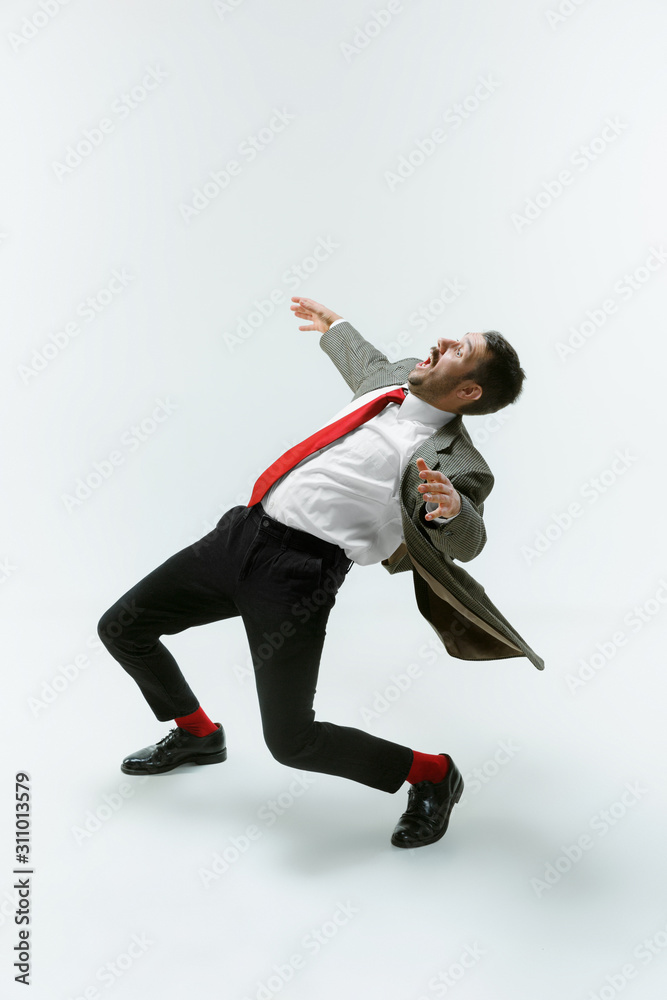Young caucasian man moving flexible on white studio background. Male ...