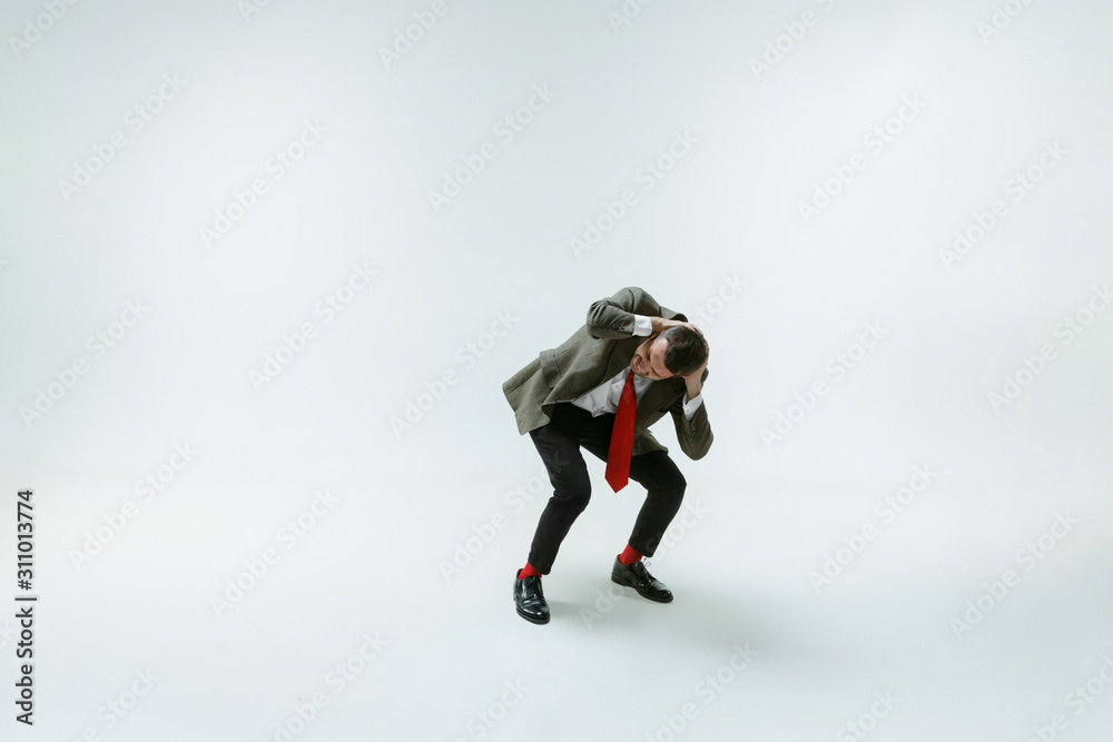 Young caucasian man moving flexible on white studio background. Male ...