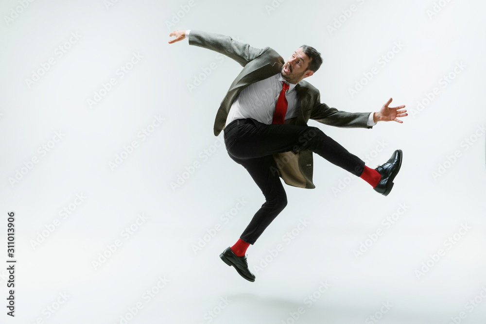 Young caucasian man moving flexible on white studio background. Male ...