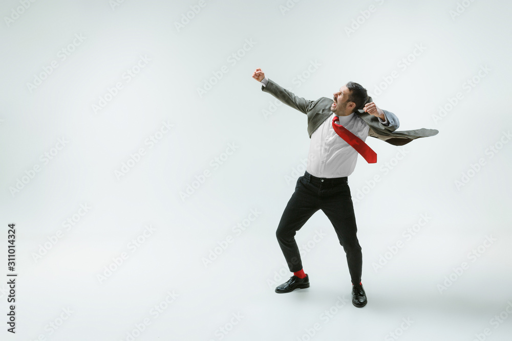 Young caucasian man moving flexible on white studio background. Male ...