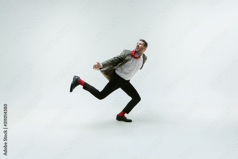Young caucasian man moving flexible on white studio background. Male ...