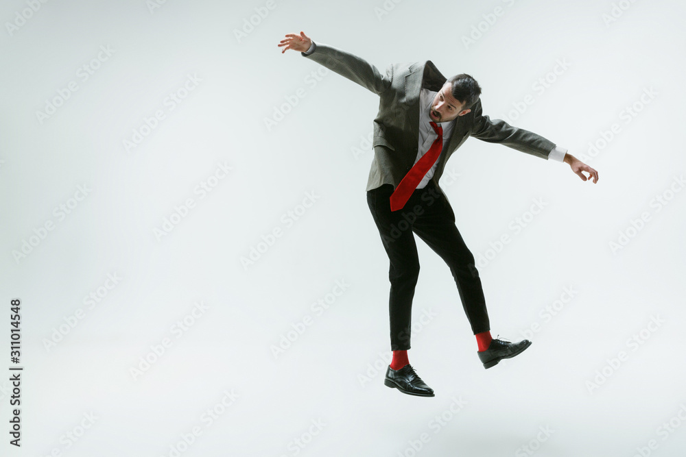 Young caucasian man moving flexible on white studio background. Male ...