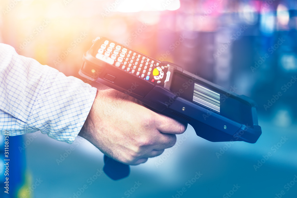 Modern warehouse management. Hand terminal for logistics. Scanning ...