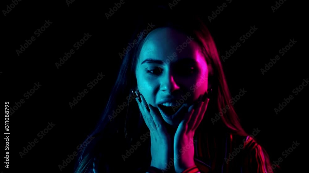 Surprised woman face in neon light. Close up of surprised girl face ...