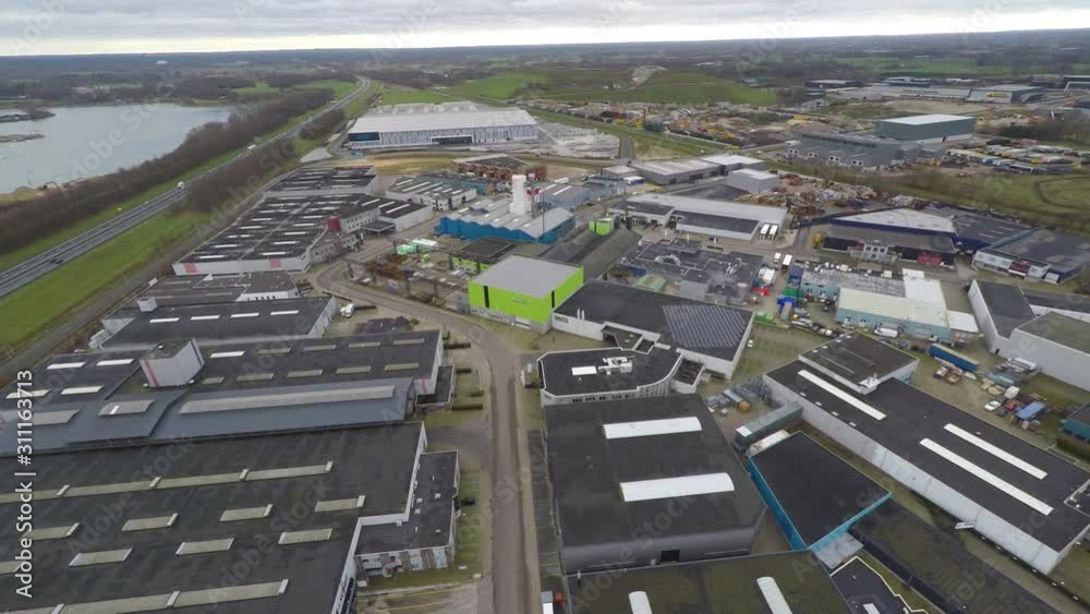 High aerial of large industrial zone with a green building sticking out ...