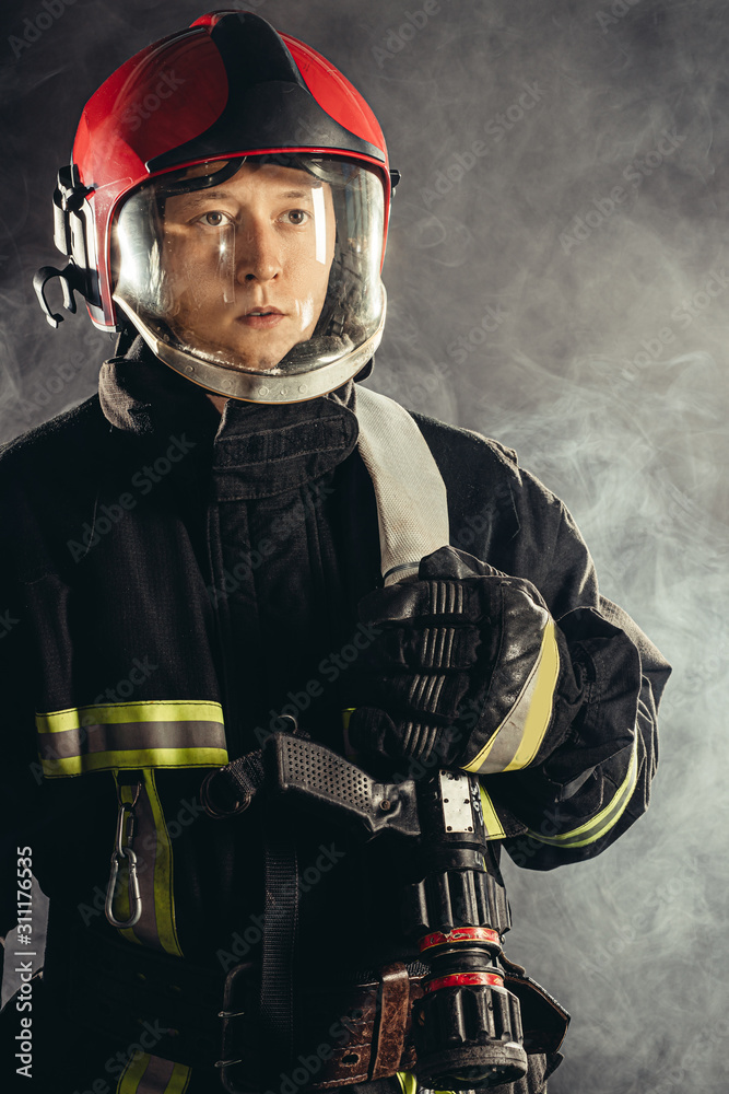 young adult firefighter saving people from fire wearing uniform and ...