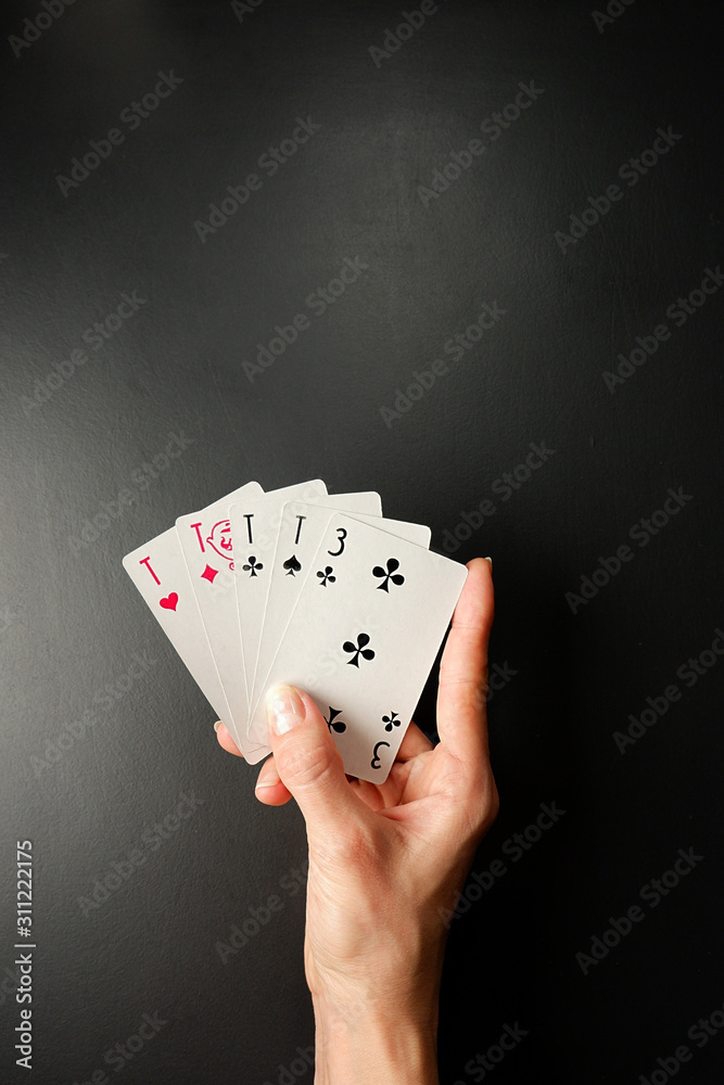 Cards in a hand on a black background. Rules and combinations of the ...