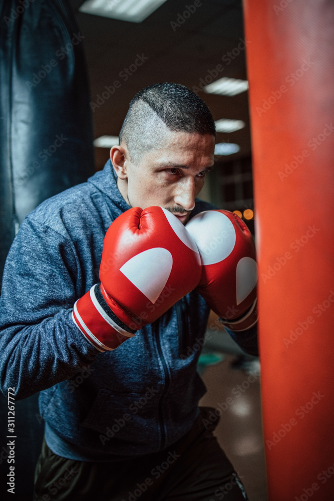 Boxer looks evil at the punching bag. Promotional picture for boxing ...