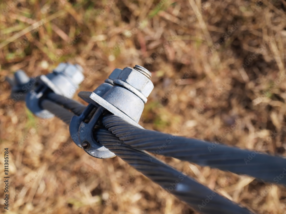 Closeup Clamp Holds Guy Wire Mounted with Anchor To help pull the pole ...