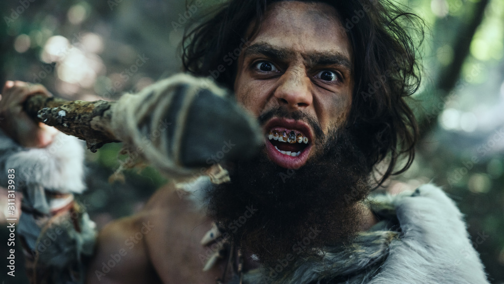 Portrait of Primeval Caveman Wearing Animal Skin and Fur Hunting with a ...