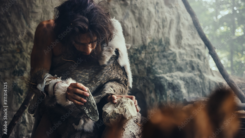 Close-up Shot of a Primeval Caveman Wearing Animal Skin Hits Rock with ...