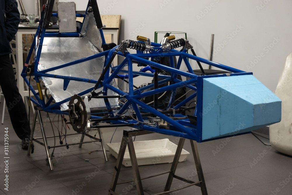 Custom car being build in workshop. Sports car body, car frame is ...