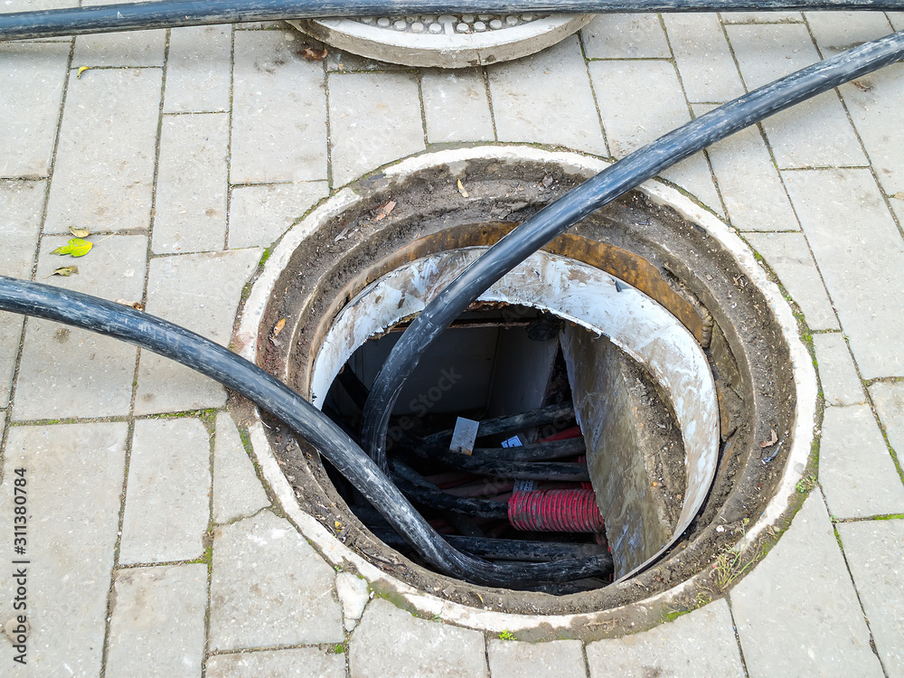 Open manhole for cable replacement on the sidewalk. Laying of new ...