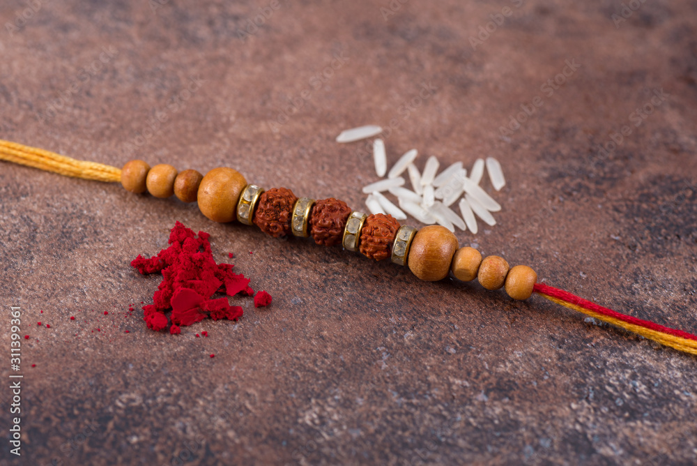 Raksha Bandhan : Rakhi with rice grains and kumkum on stone background ...