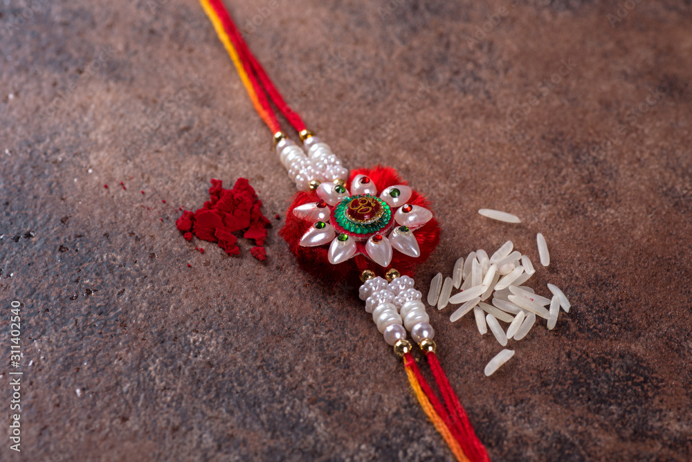 Raksha Bandhan : Rakhi with rice grains and kumkum on stone background ...