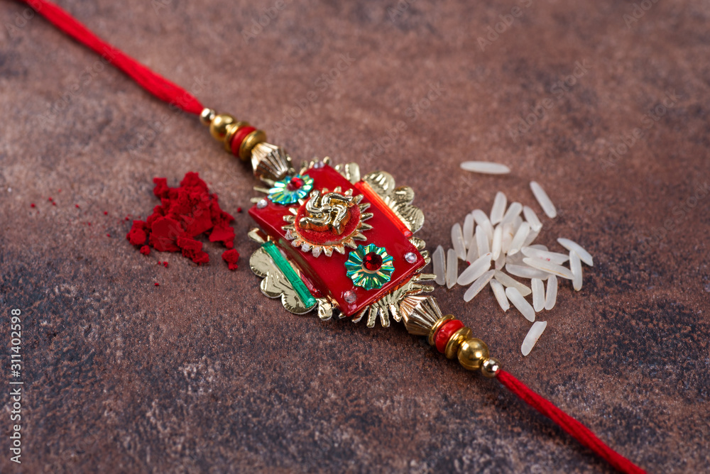 Raksha Bandhan : Rakhi with rice grains and kumkum on stone background ...