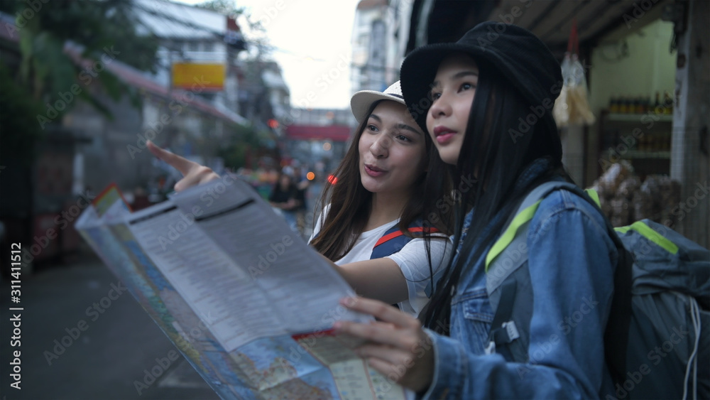 Travel concept. Beautiful girls are reading the map on the roadside. 4k ...
