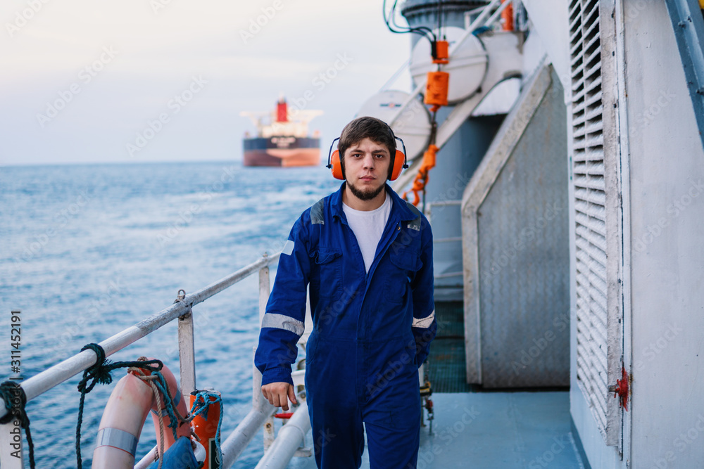 Engineer or officer on deck of offshore vessel or ship , wearing PPE ...
