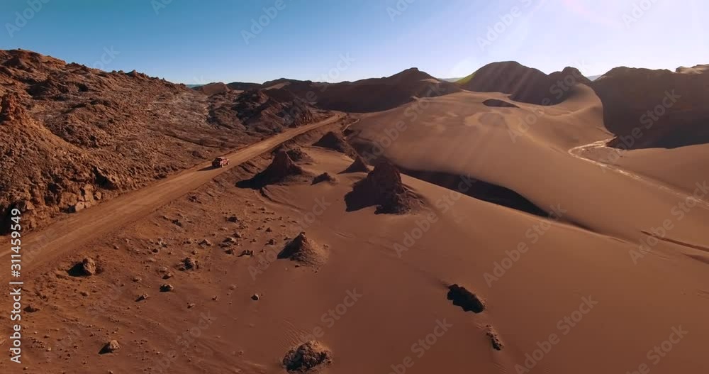 Sun rays lit the lifeless landscape of Atacama desert. The car moves ...