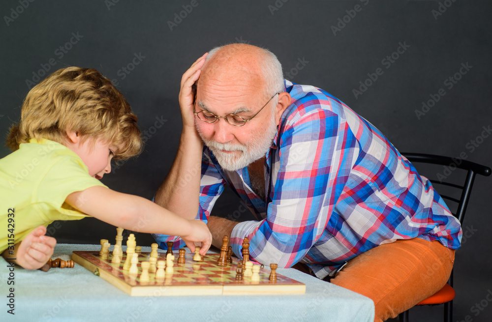 Chess match. Board games. Little boy playing chess with grandfather ...