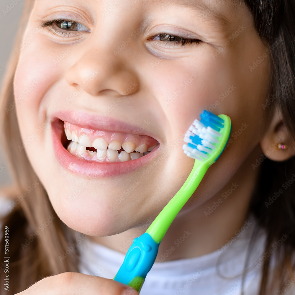 Beautiful smiling preschool girl with her first adult incisor tooth ...