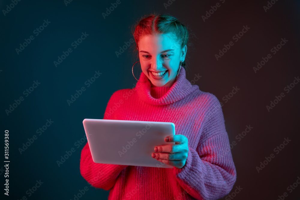 Using tablet, looks happy. Caucasian woman's portrait isolated on ...