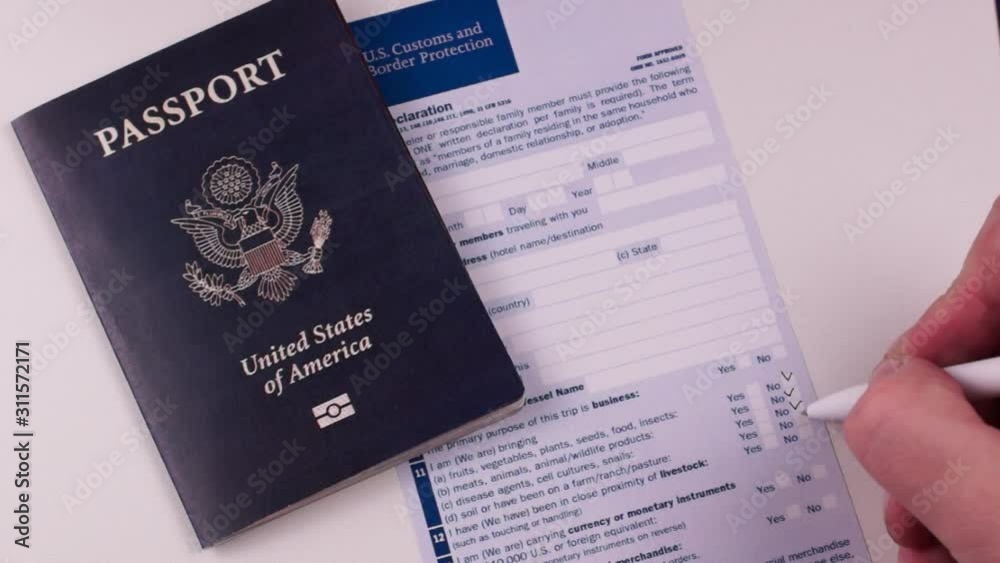 Man fills out a customs declaration form next to an American passport ...