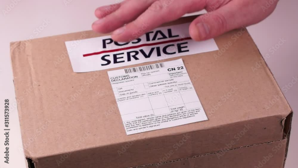 Human sticks a Customs declaration form CN22 on a Parcel with a label ...