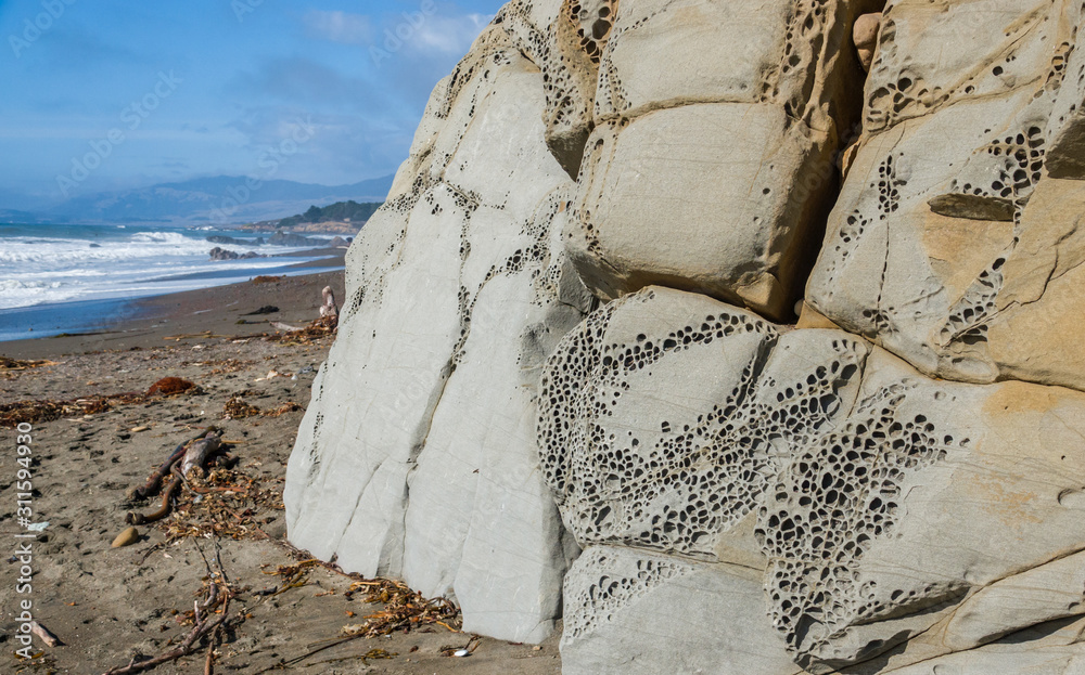 Unusual erosion weathered patterns in the sandstone are seen at ...