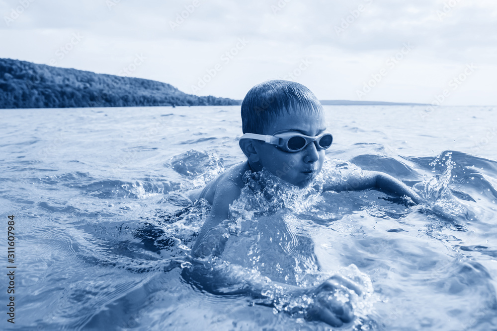 Caucasian boy swimming in lake river with underwater goggles. Child ...