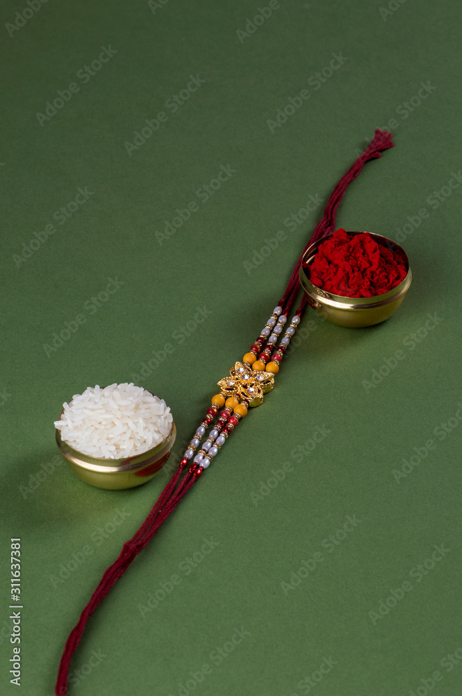 Indian festival: Raksha Bandhan background with an elegant Rakhi, Rice ...