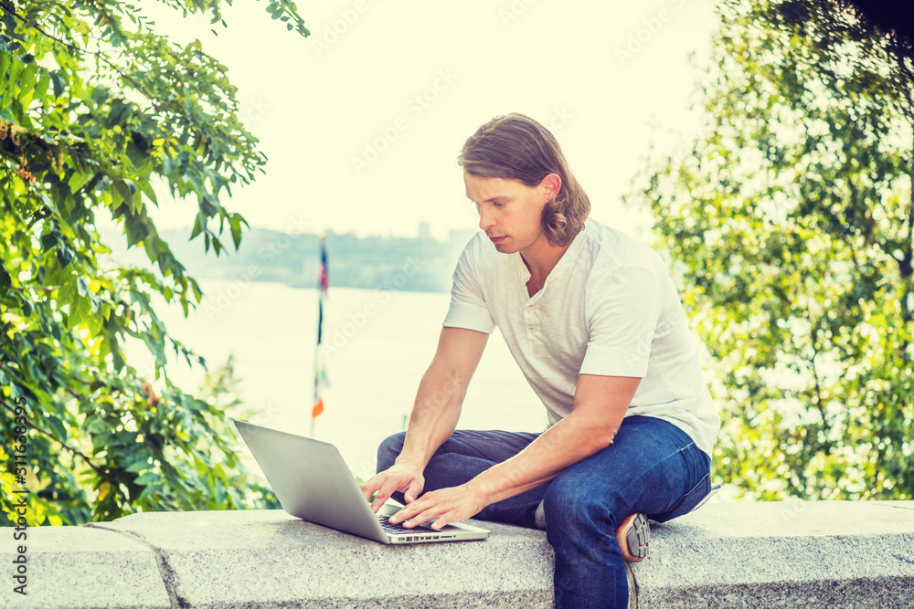 Foto de Young American Man with long dark brown hair working on laptop ...