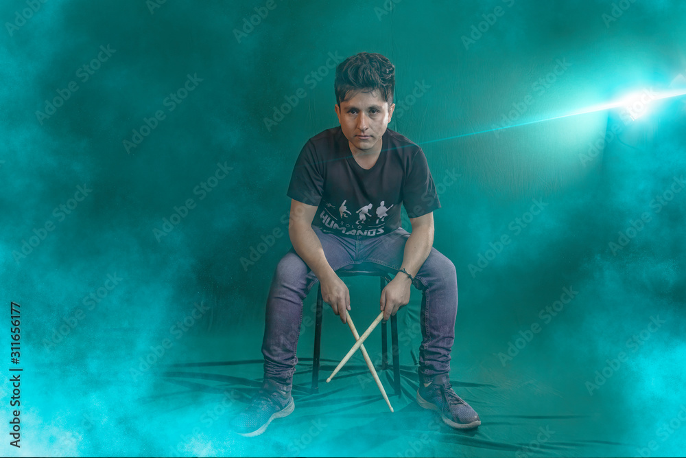 Rock band drummer raising his arms, throwing drumsticks in the air on ...