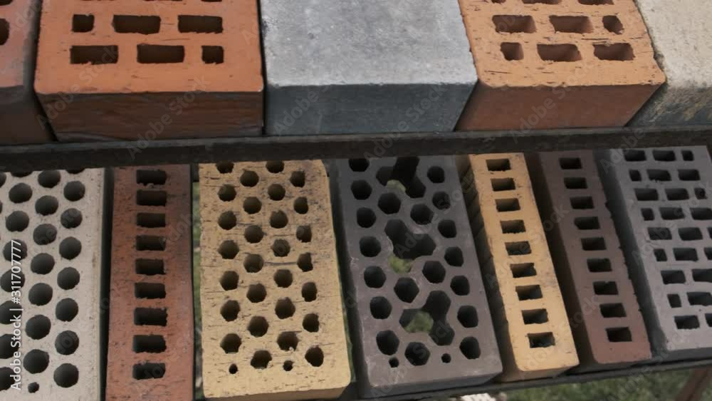 Samples of bricks differ in shape and color displayed in a row at the ...