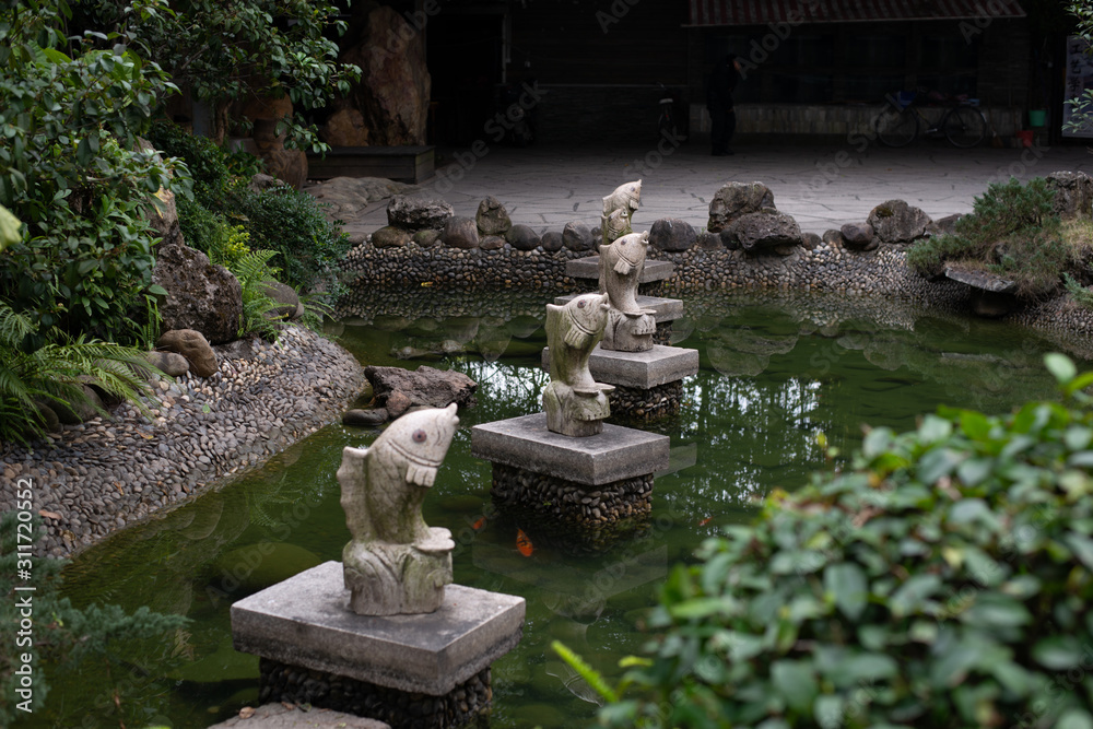 Chinese pond with statues of fishes in the park, green water Stock ...