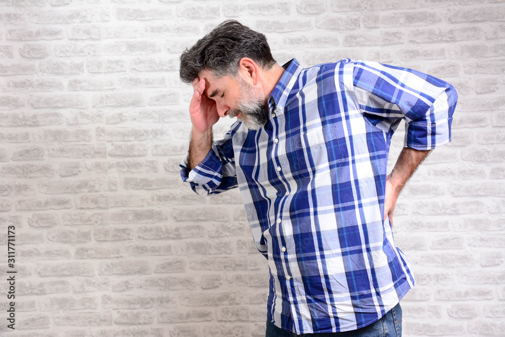 Handsome old man is having back pain at home. Unhappy senior man ...