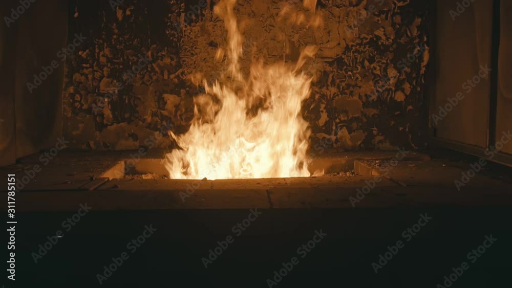 Forge fire in furnace. Blacksmith tempers a steel product in a stove ...