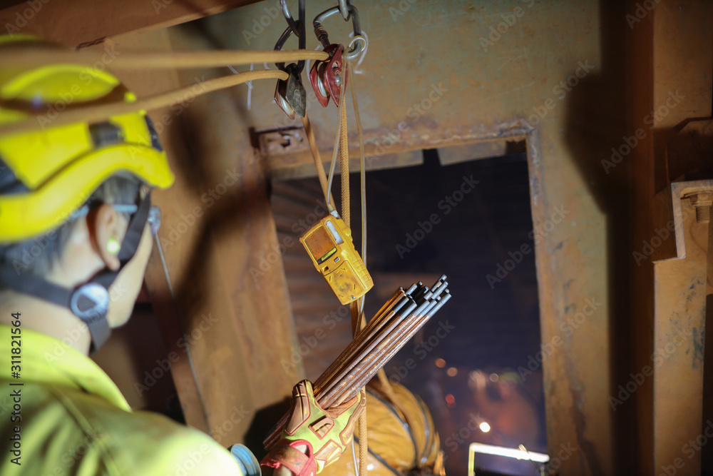Male worker wearing a safety hard hat, glove holding handful colourful ...